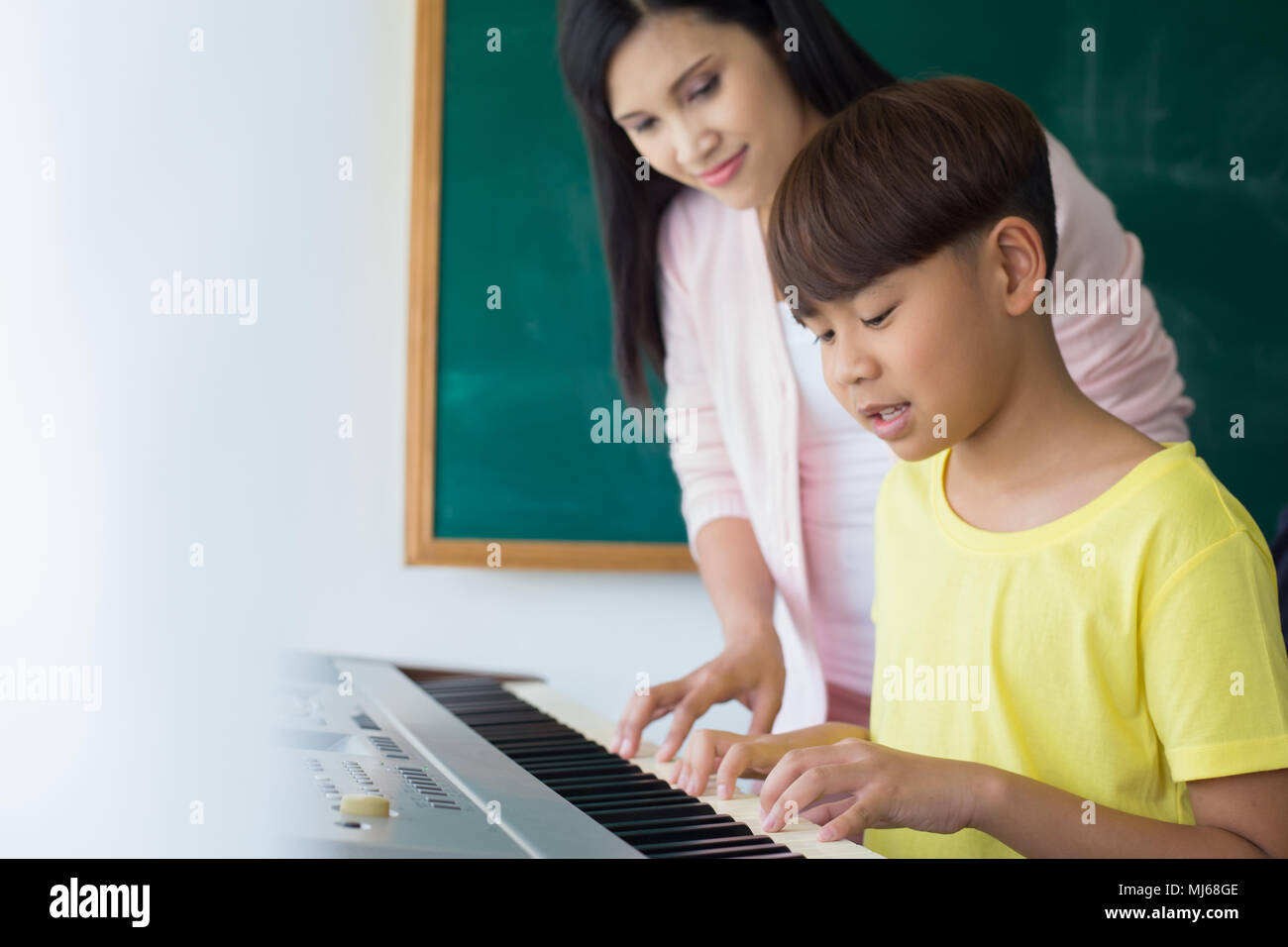 a music teacher with the pupil at the lesson piano Stock Photo - Alamy