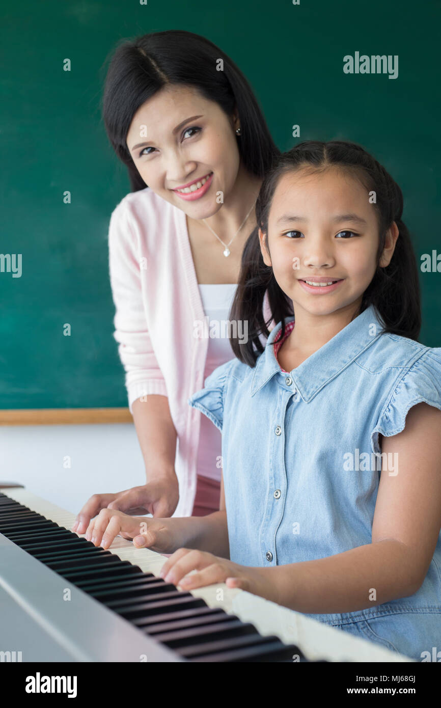 a music teacher with the pupil at the lesson piano Stock Photo - Alamy