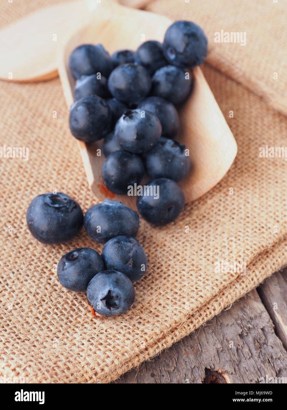 Fresh blueberries on a wooden spoon, healthy eating or food background ...
