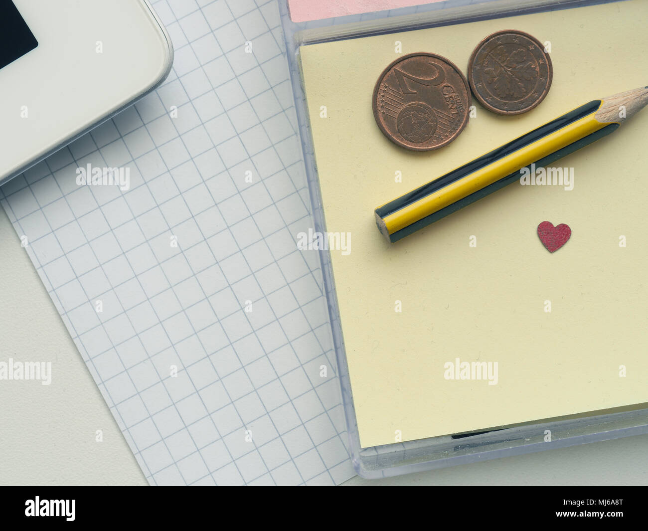 Sticky notes with a small pencil and heart shape on an office table ...