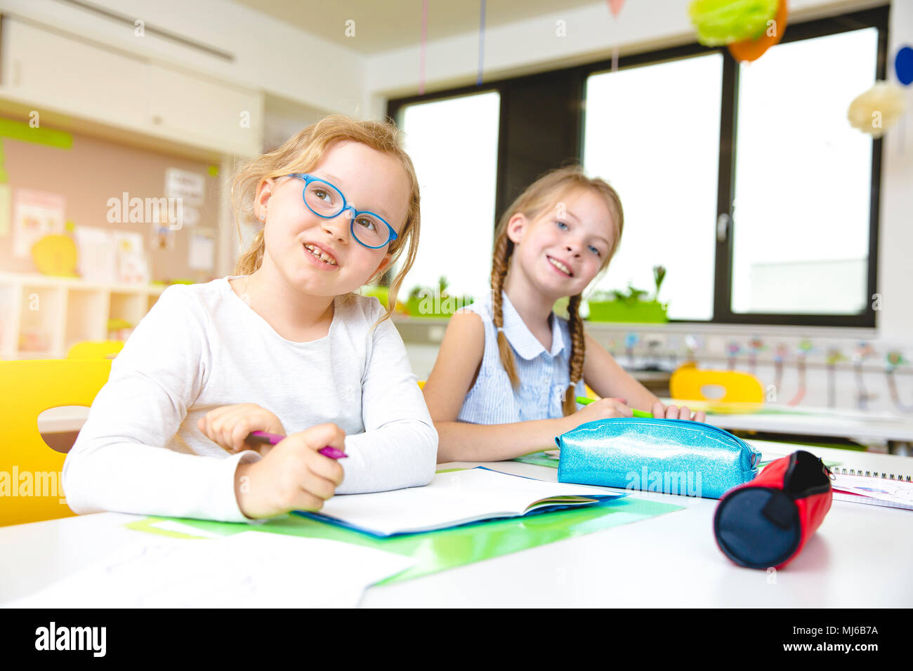 Beautiful young kids have fun in school while learning in classroom ...