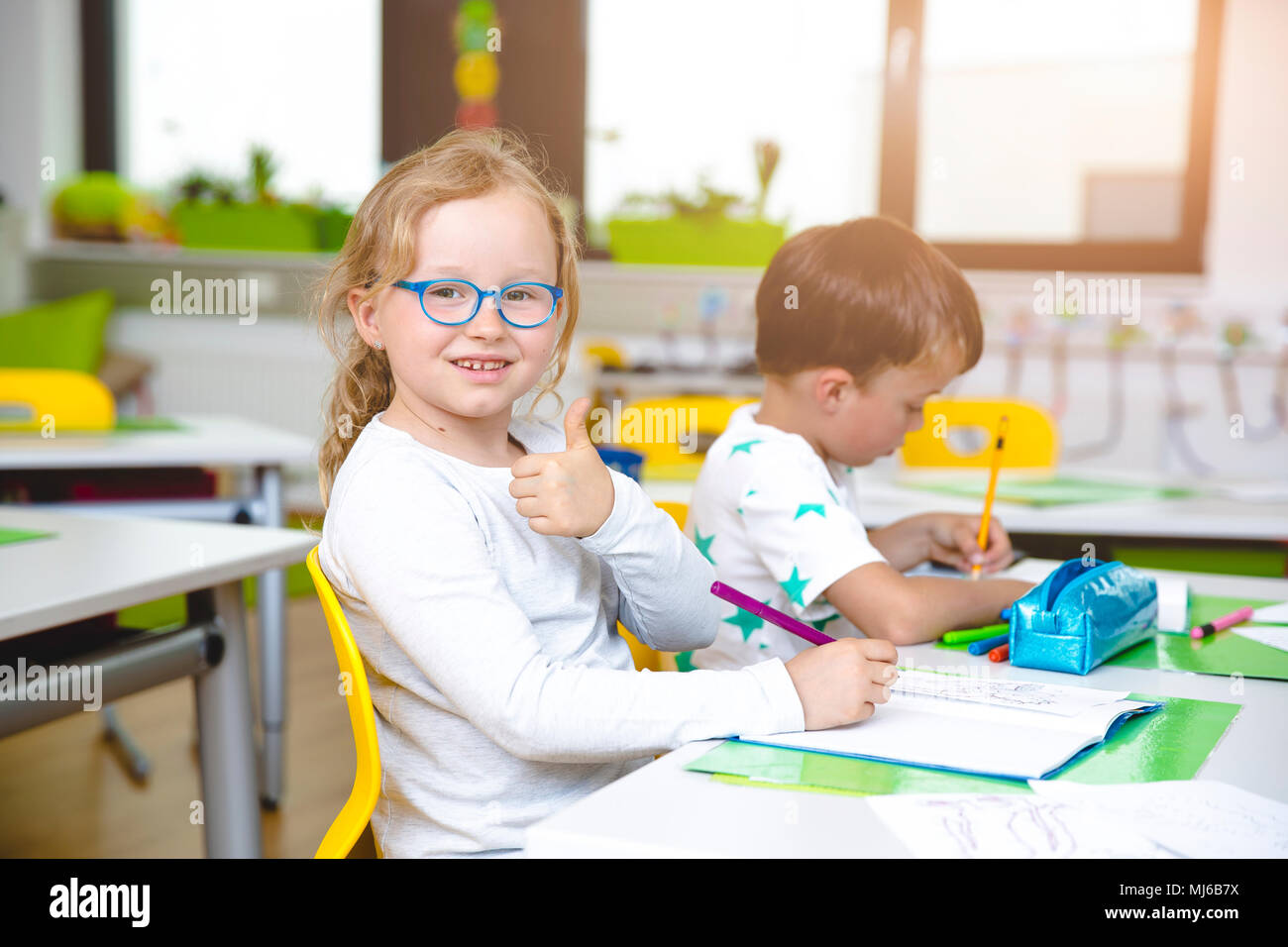 Beautiful young kids have fun in school while learning in classroom ...