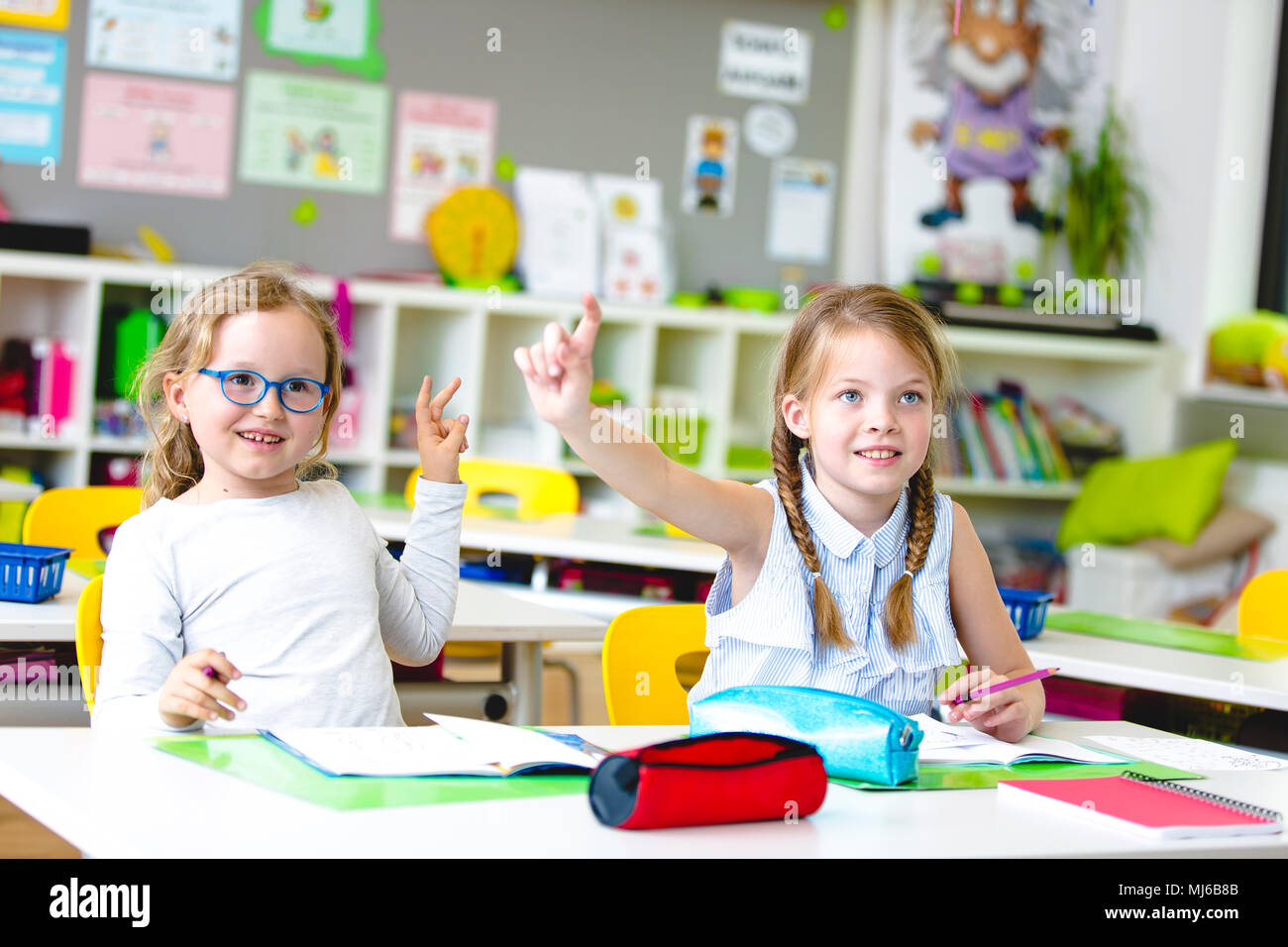 Beautiful young kids have fun in school while learning in classroom ...
