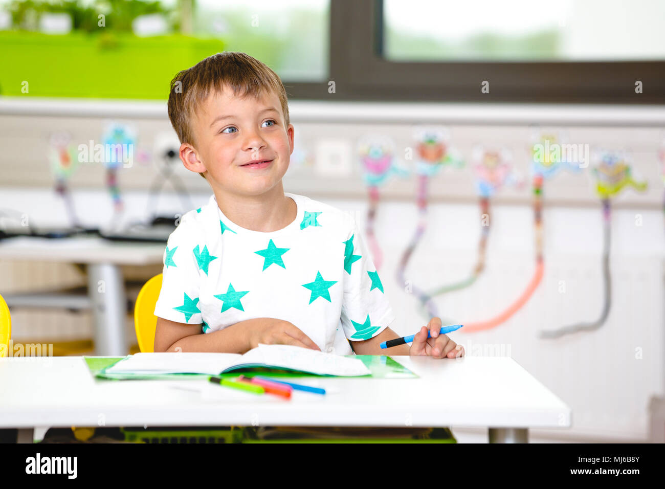 Beautiful young kids have fun in school while learning in classroom ...