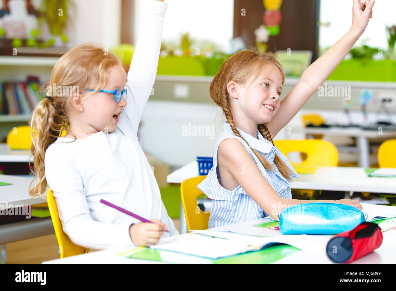 Beautiful young kids have fun in school while learning in classroom ...