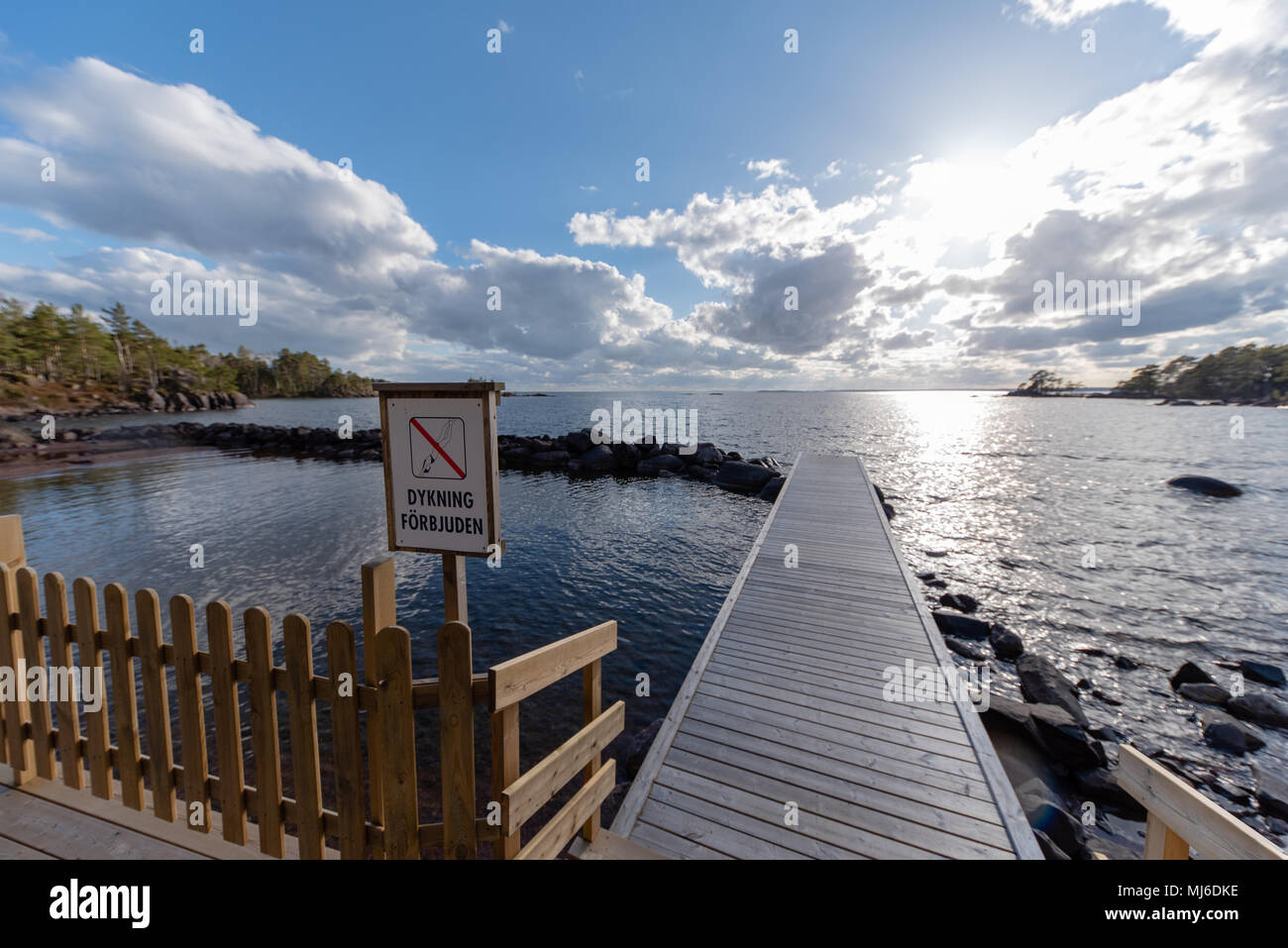 wooden jetty with a sign diving forbidden in swedish Stock Photo - Alamy