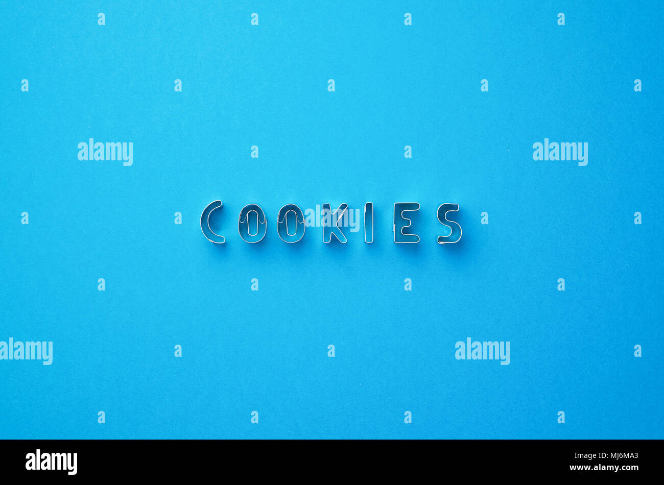 Cookies word written with cookie cutters molds over blue background ...