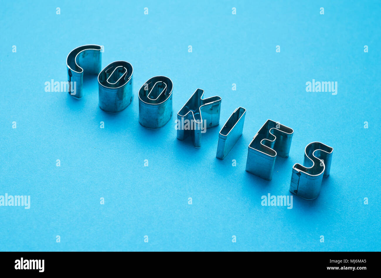 Cookies word written with cookie cutters molds over blue background ...