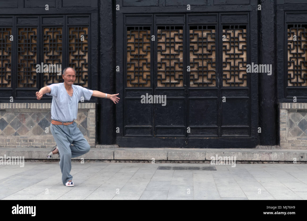 Old Chinese man practicing tai chi martial art for good health and ...
