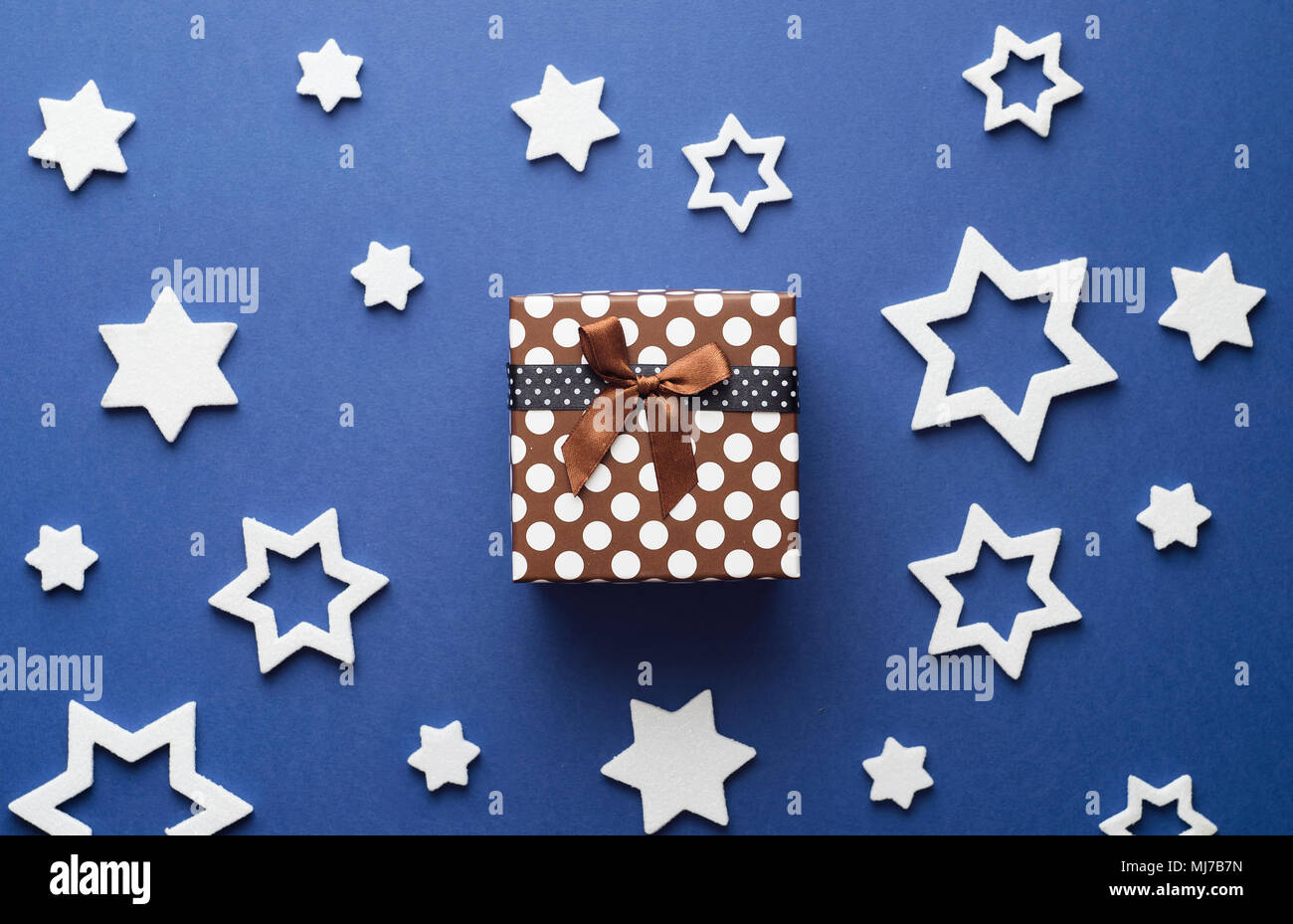 Christmas Gift Box and white stars over dark blue background, above ...