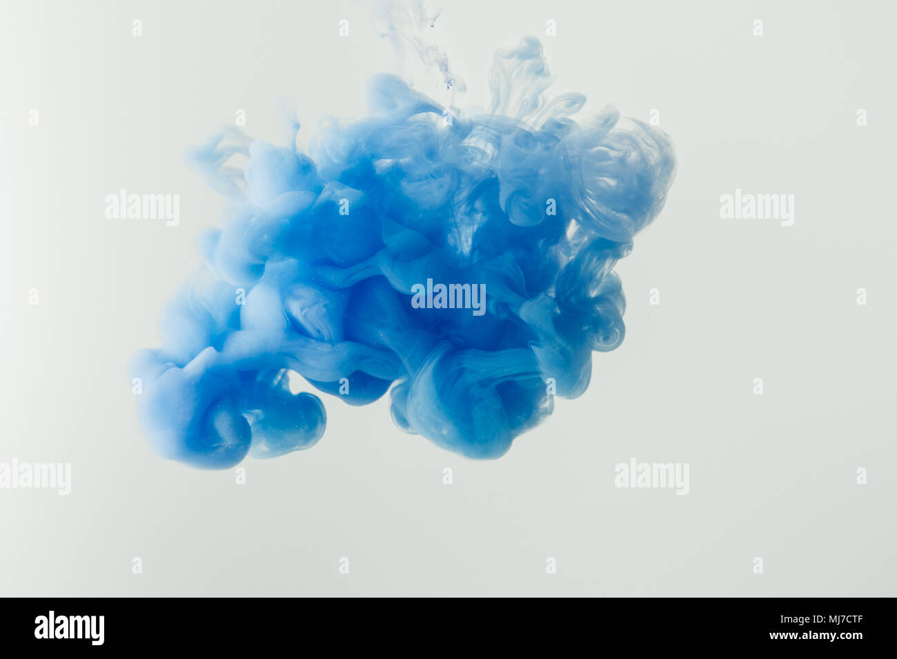 close up shot of bright blue paint splash in water isolated on gray ...