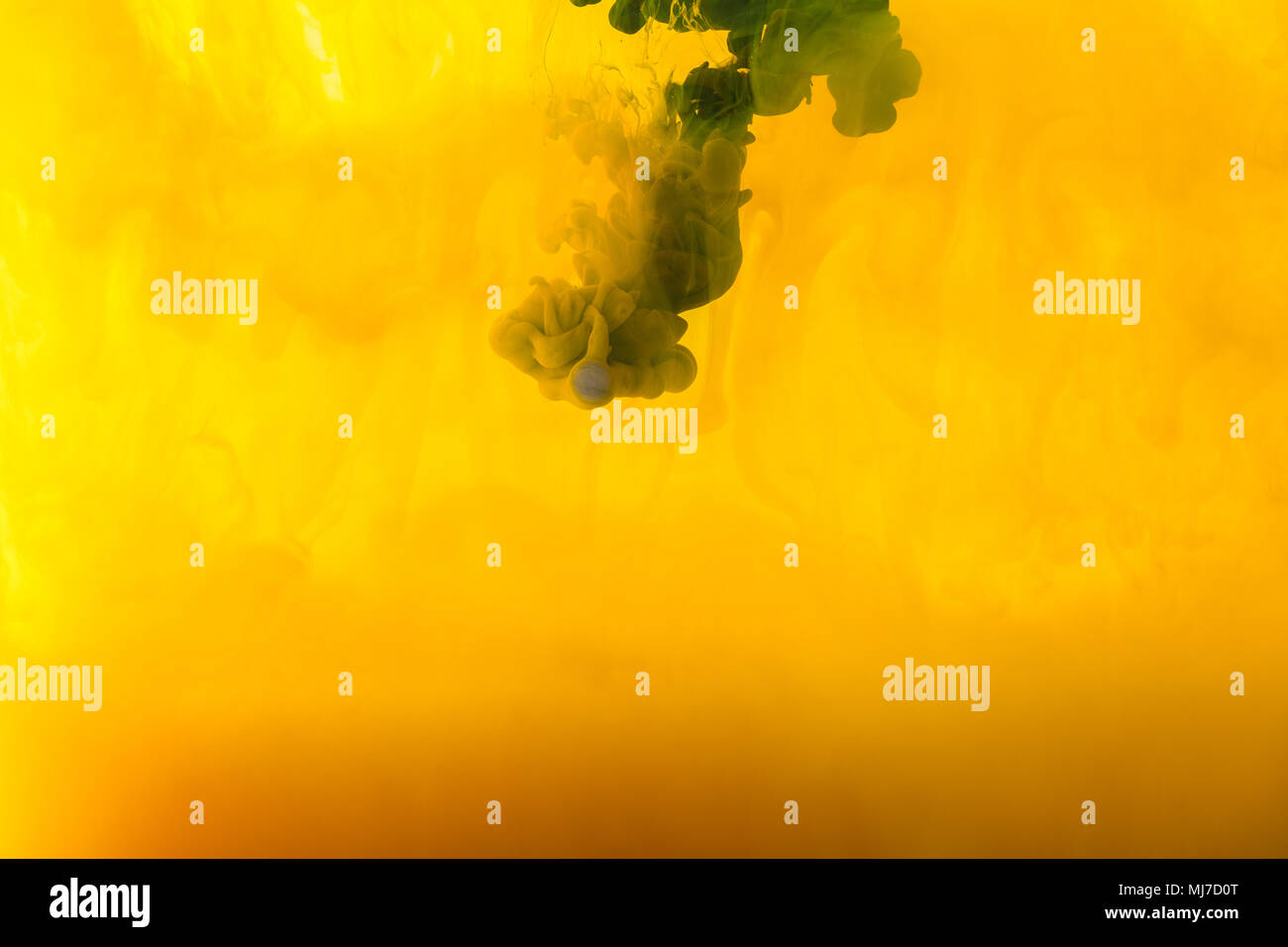 full frame image of mixing of yellow and green paints splashes in water ...