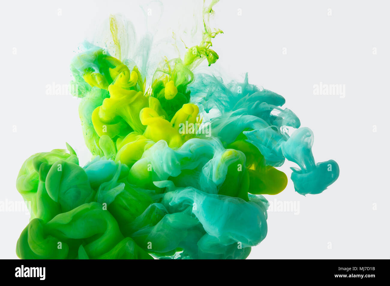 close up view of mixing of green, yellow and bright turquoise paints ...