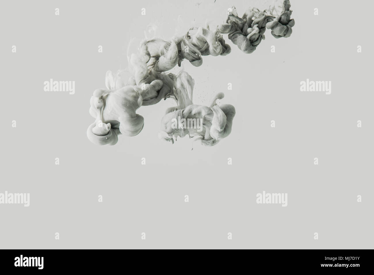 close up view of bright light gray paint splash in water isolated on ...