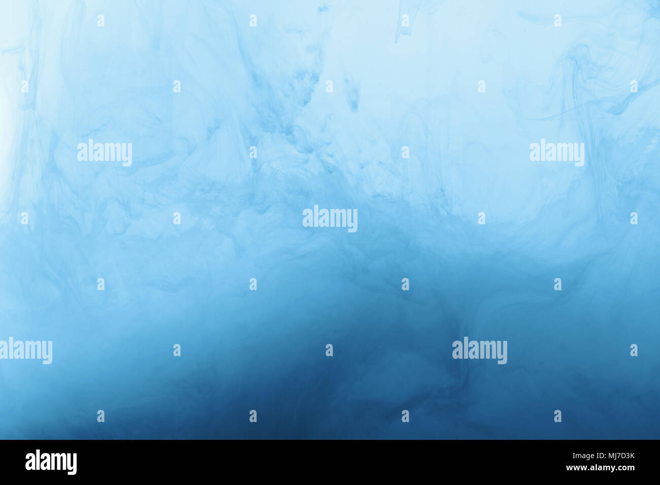 full frame image of mixing of bright pale blue and blue paints splashes ...