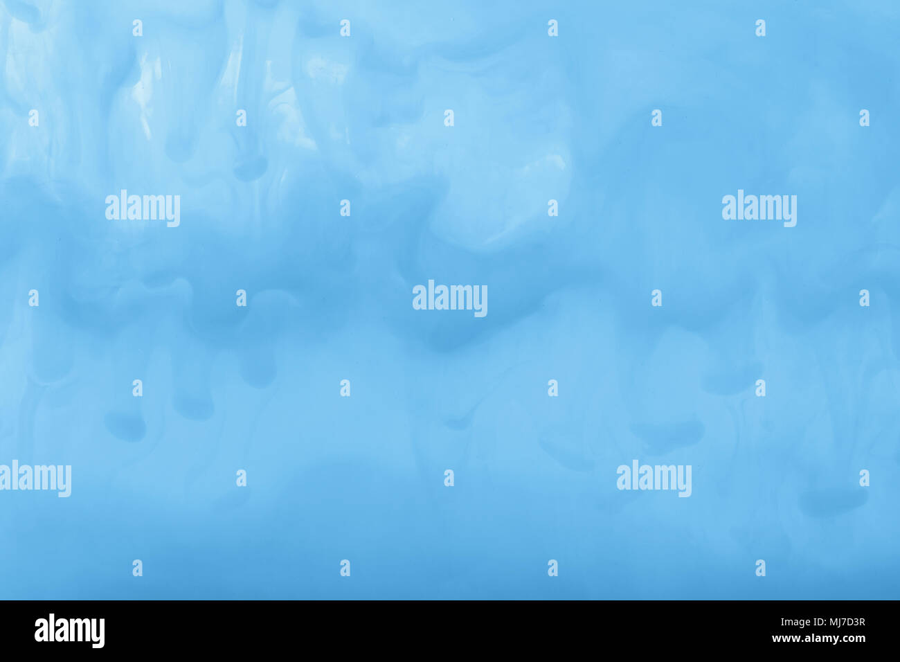 background with mixing of bright pale blue and blue paints splashes in ...