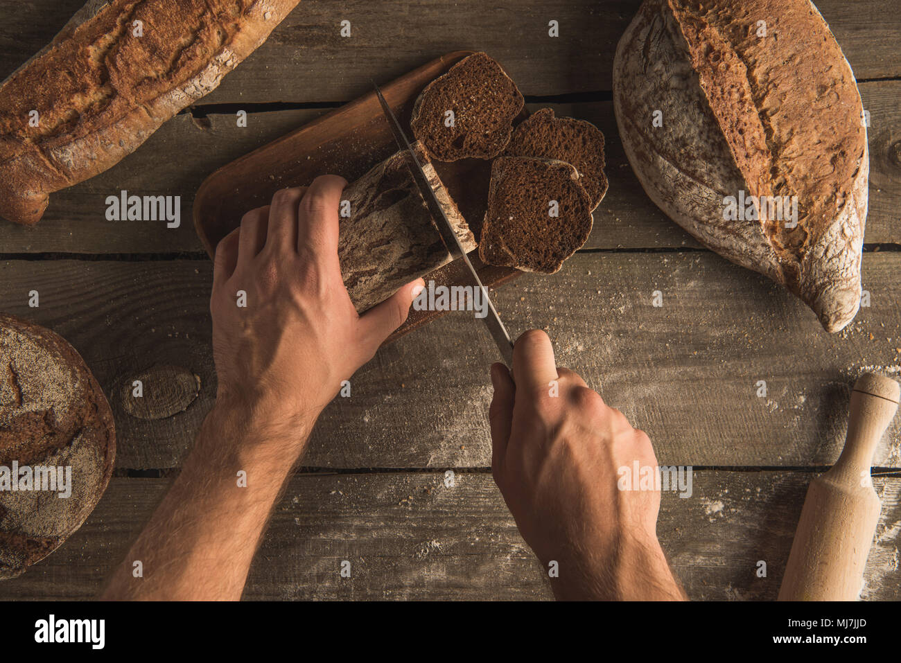 person cutting loaf of bread Stock Photo - Alamy