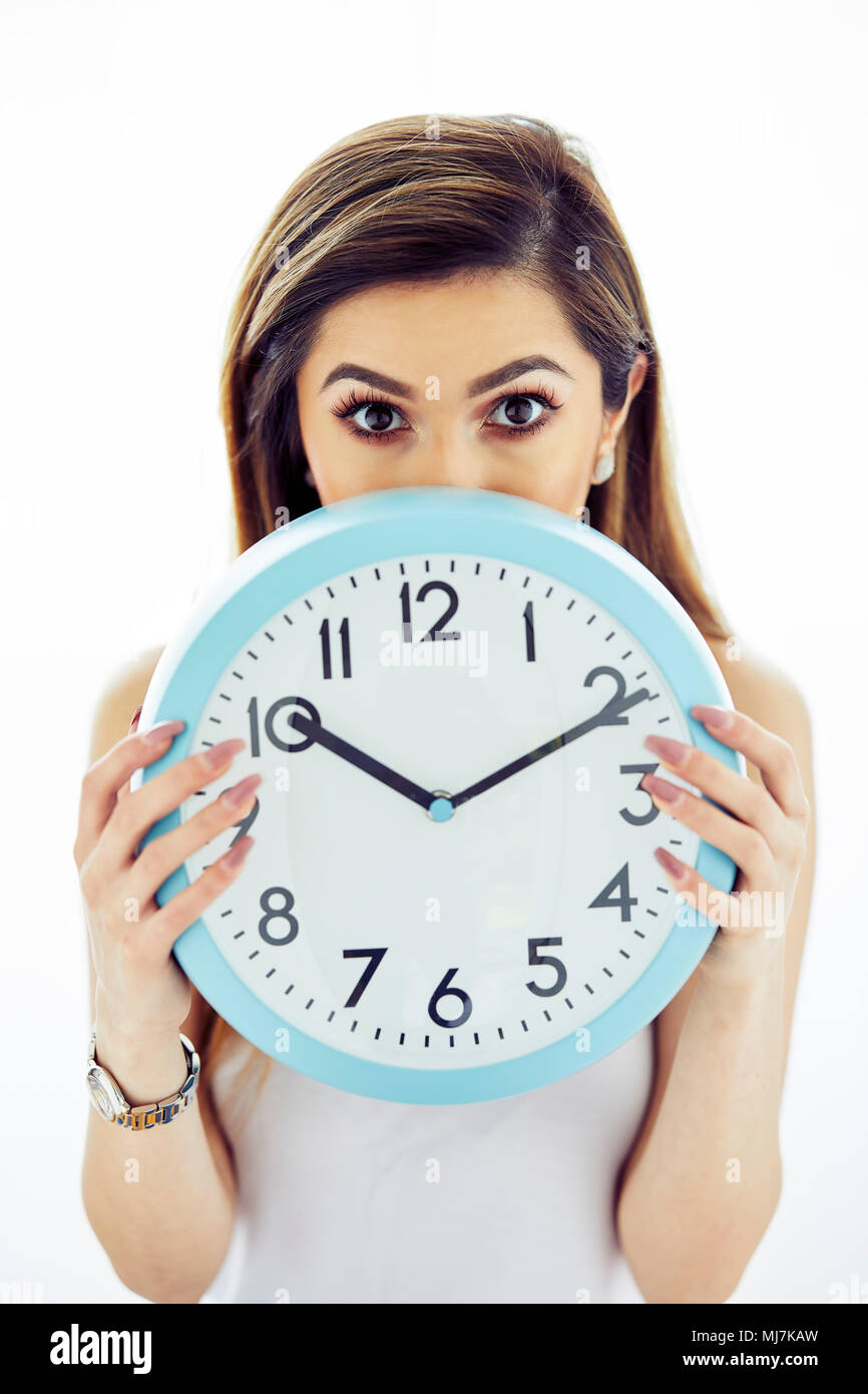 Girl looking over the top of a clock face Stock Photo - Alamy
