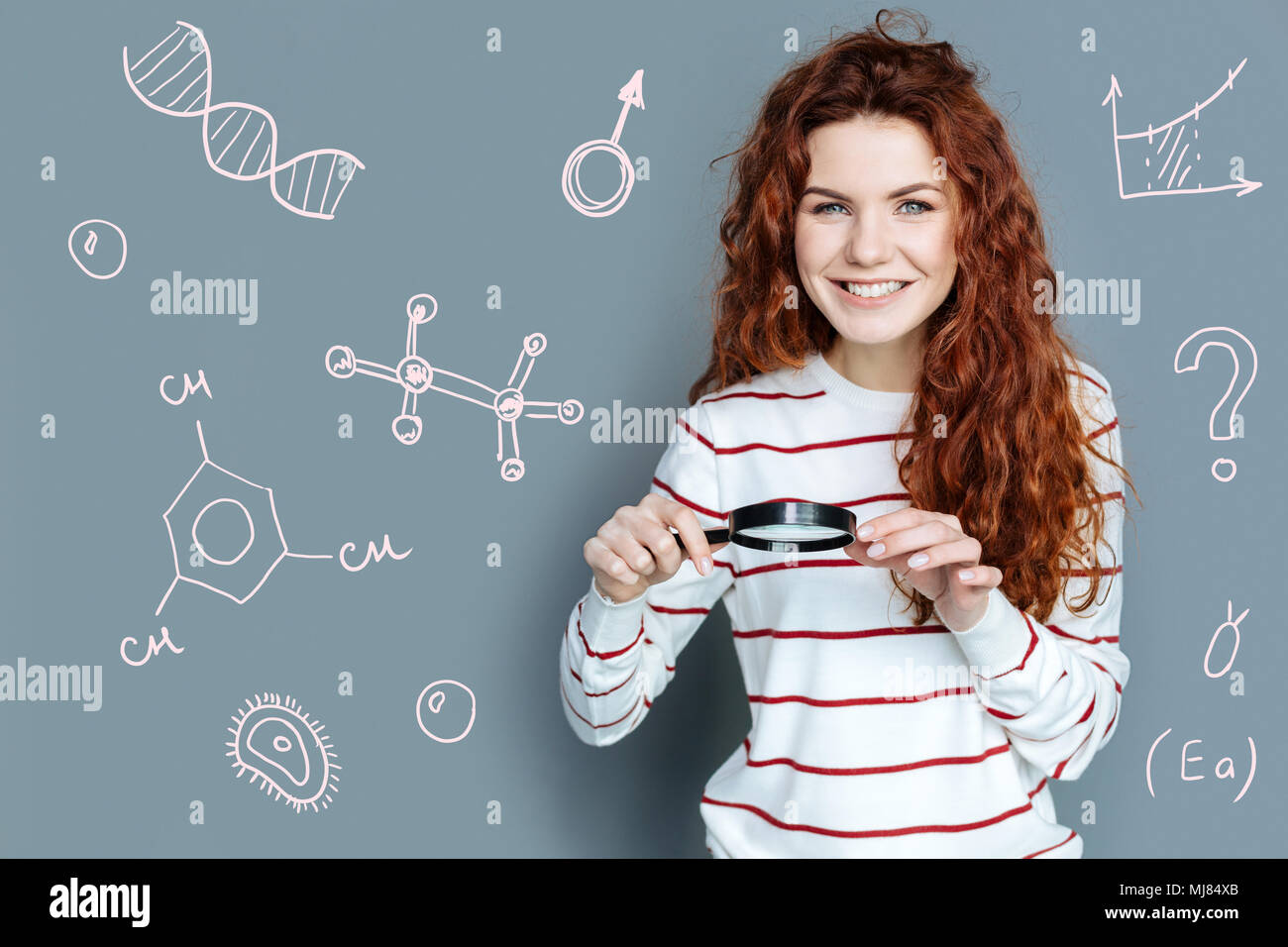 Emotional scientist holding a magnifying glass and smiling Stock Photo ...