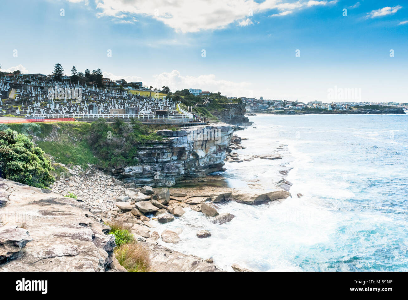 A graveyard on the sea front, with fallen rocks and boulders below ...