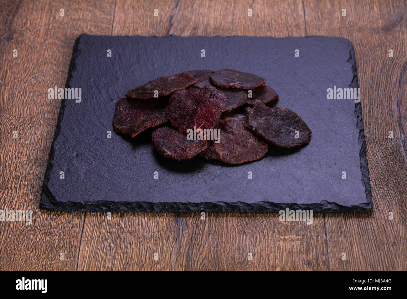 Dry beef meat over wooden Stock Photo - Alamy