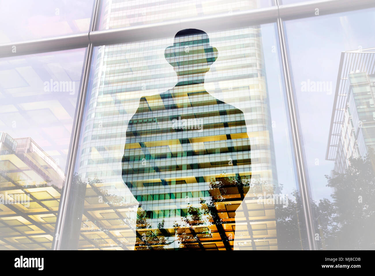Rear view of man standing at window, reflection of illuminated ...