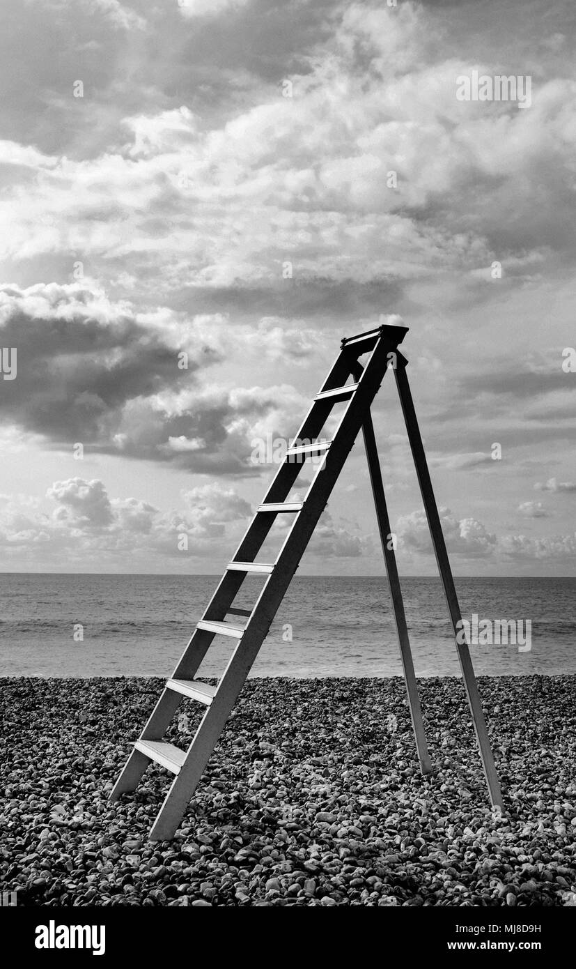Ladder standing on pebble beach by the ocean, cloudy sky Stock Photo ...