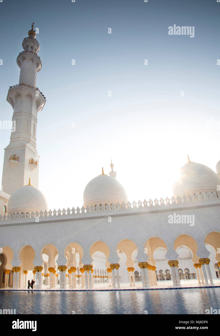 Exterior view of mosque with white washed walls and colonnade, minaret ...