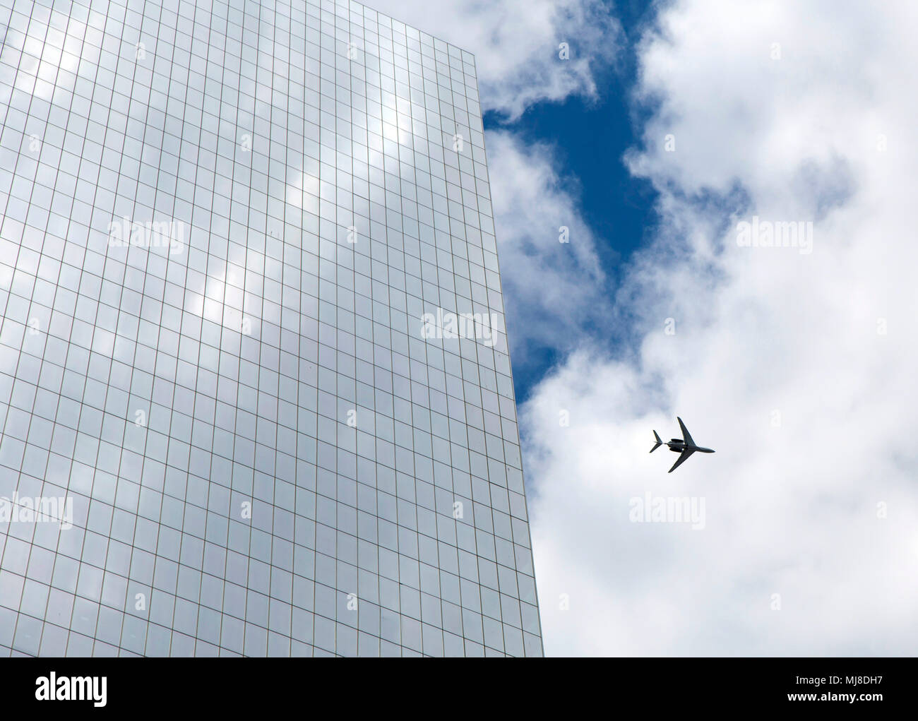 Low angle view of glass facade of contemporary skyscraper, passenger ...