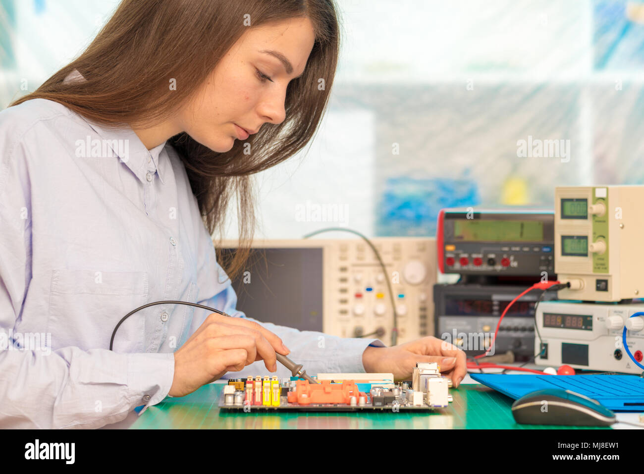 Female student in electronics class uses a Measuring device Stock Photo ...