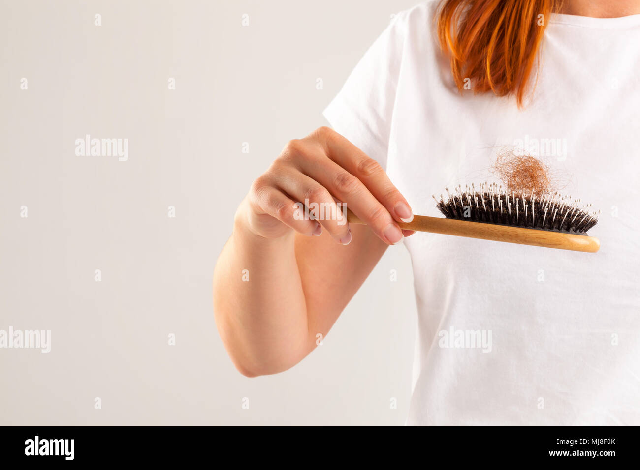 Beautiful redhair with hair tuft in comb isolated on grey background ...