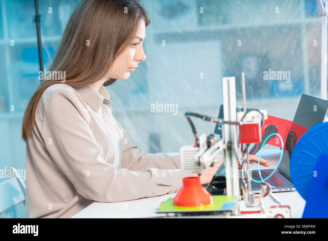 A young woman design a model of an artificial organ on a 3D printer ...