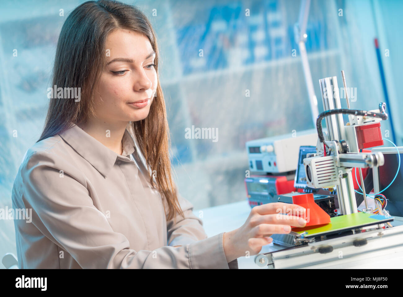 A young woman design a model of an artificial organ on a 3D printer ...