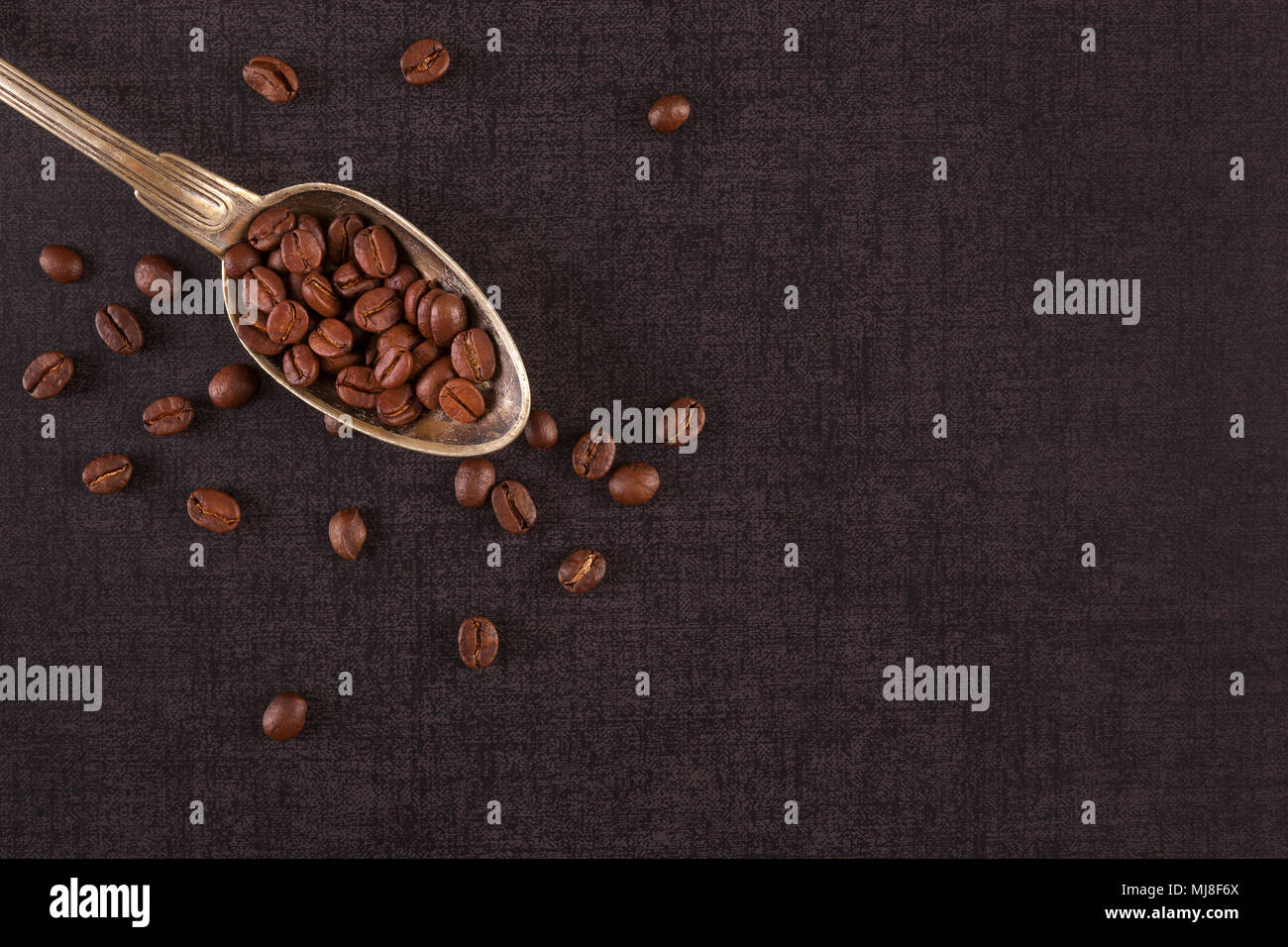 Coffee beans in spoon from above dark surface Stock Photo - Alamy