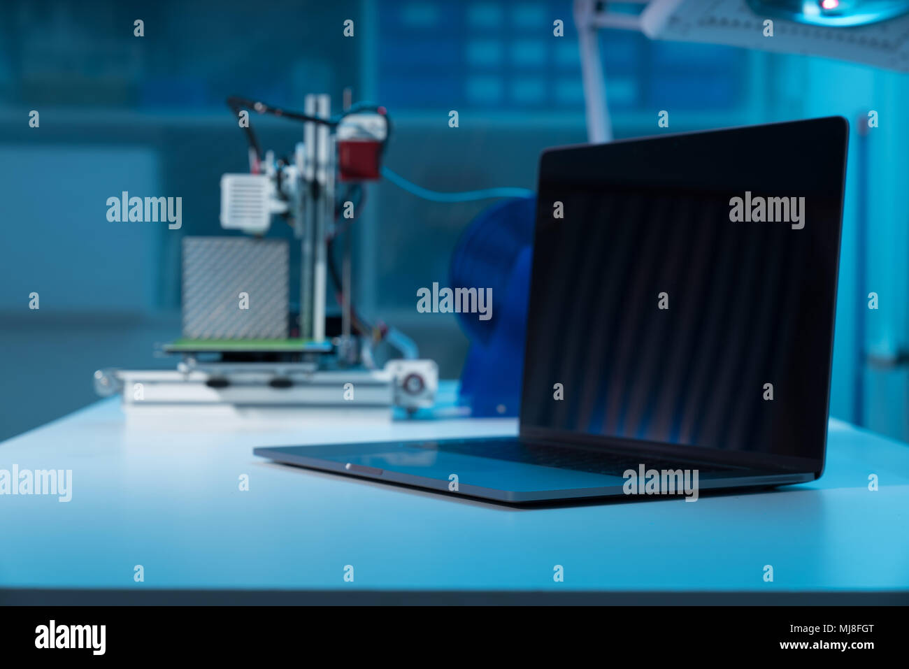 Computer and 3d printer on table in industrial design lab Stock Photo ...