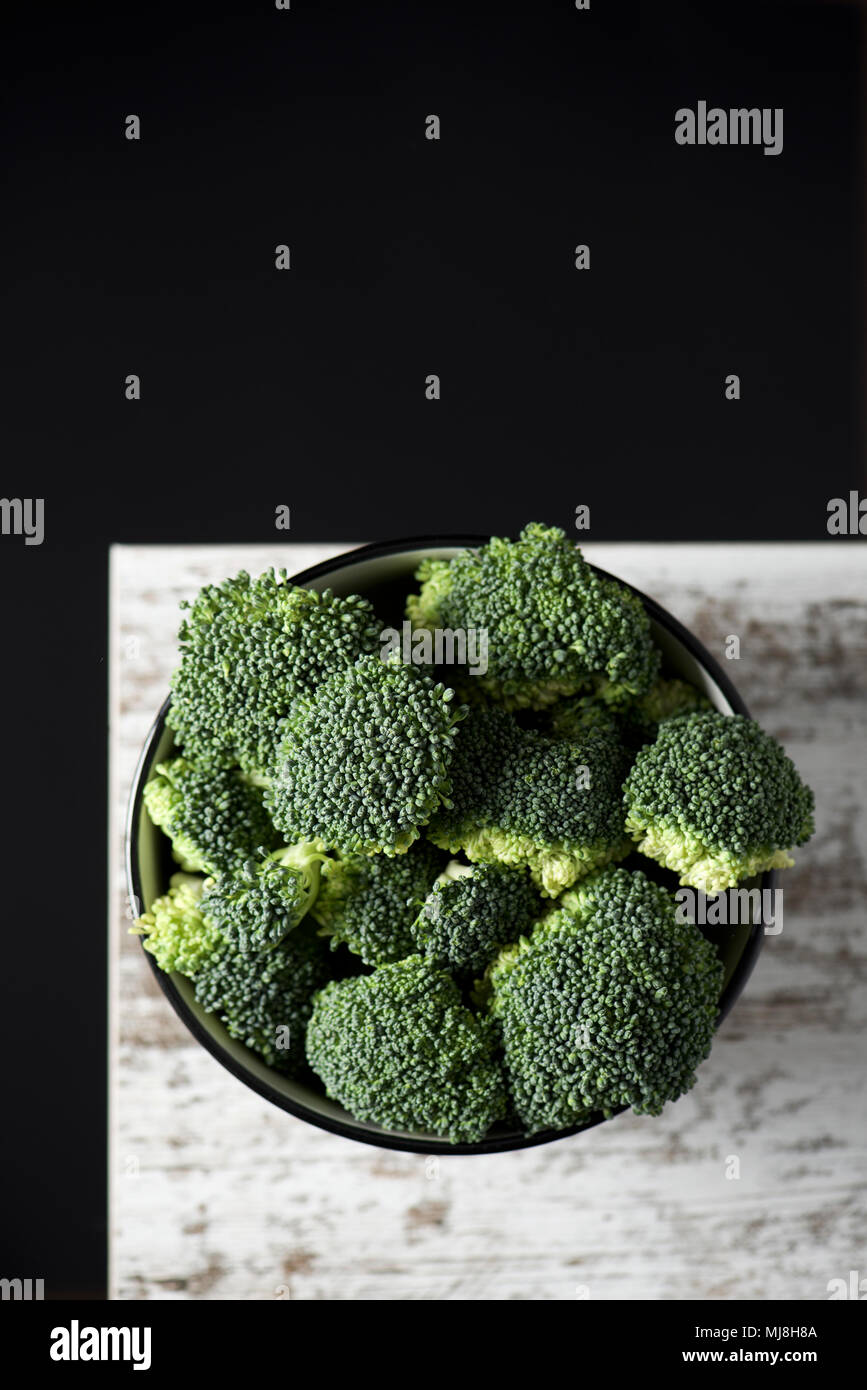 high angle view of some stems of broccoli in a white ceramic bowl, on a ...
