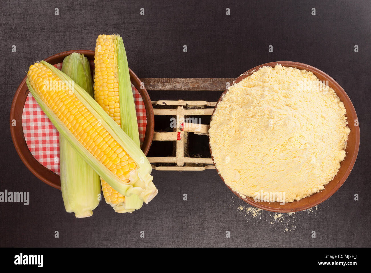 Corncobs and heap of corn flour on weighing scale from above Stock ...