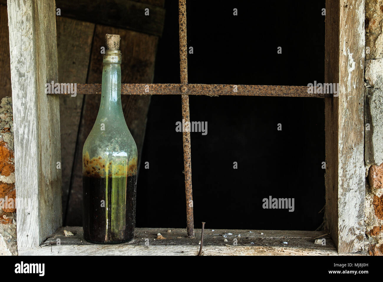 Old bottle sitting on an old window frame Stock Photo - Alamy