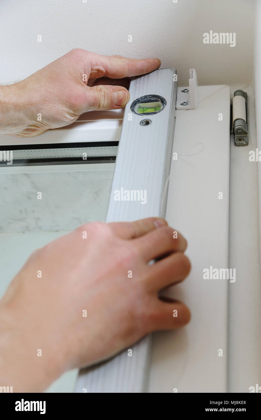 Man's hands holding level for installation the bracket correctly Stock ...