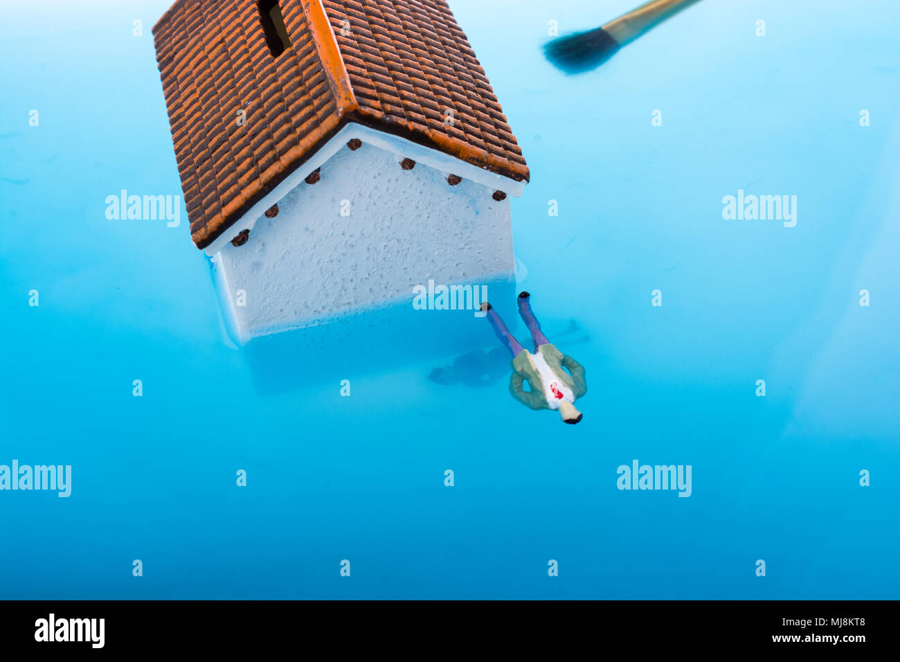 Little model house and figurines of man and woman float in water Stock ...