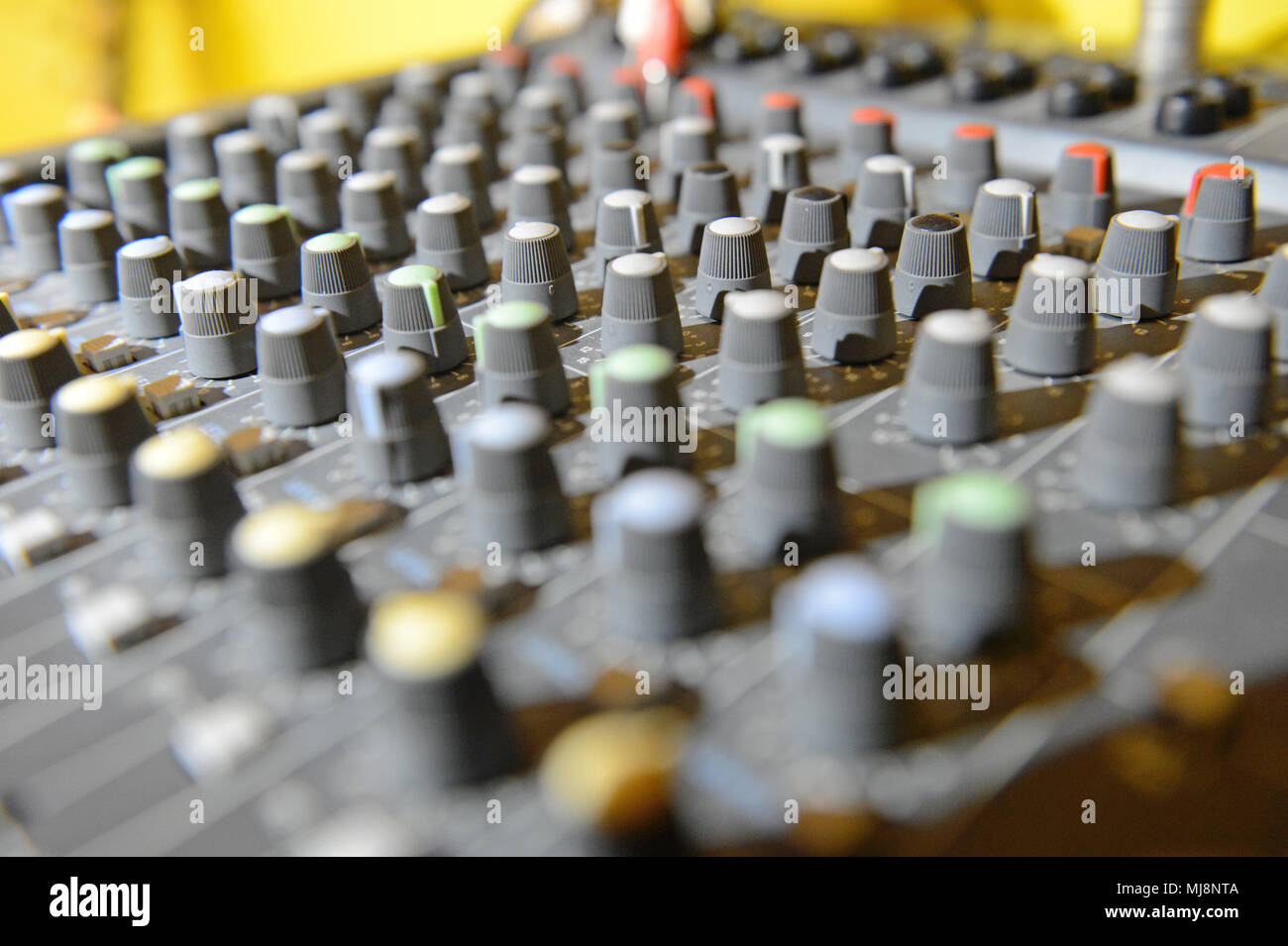 Close up of mixing desk with colourful buttons and shallow depth of ...