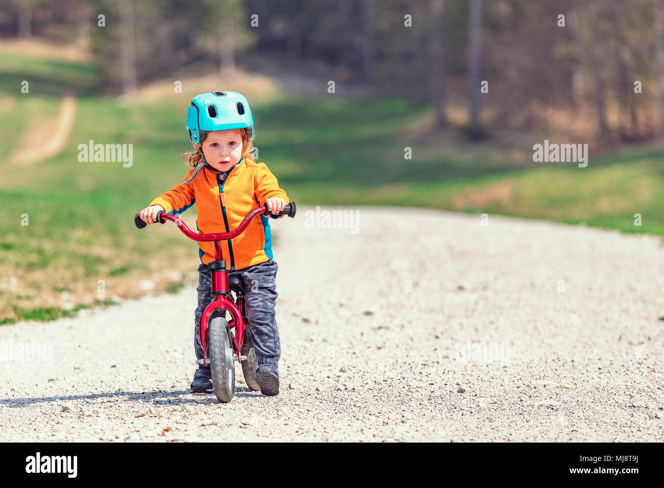 Young boy riding bicycle with training wheels hi-res stock photography ...