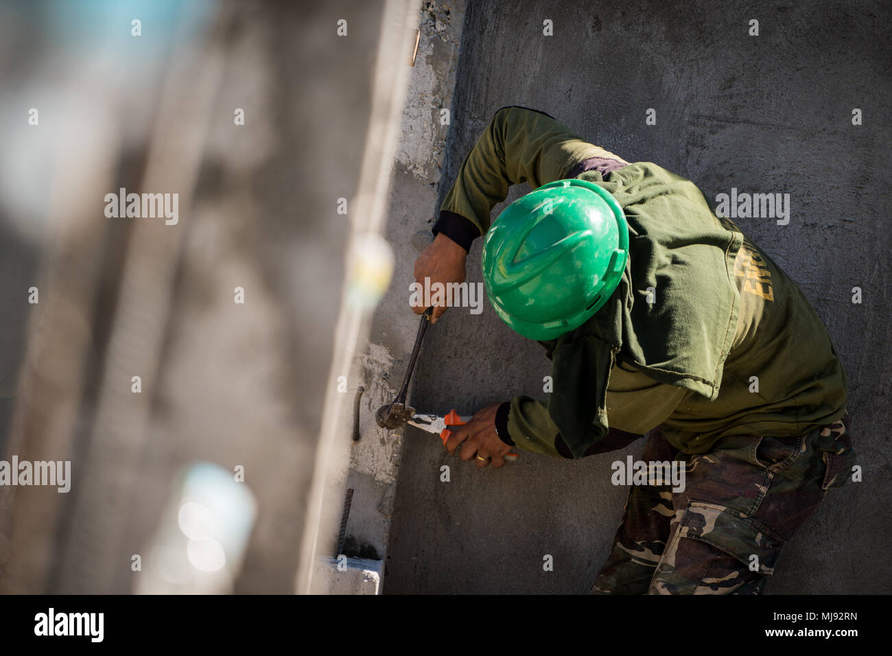 A Philippine Army engineer hammers rebar during construction in support ...