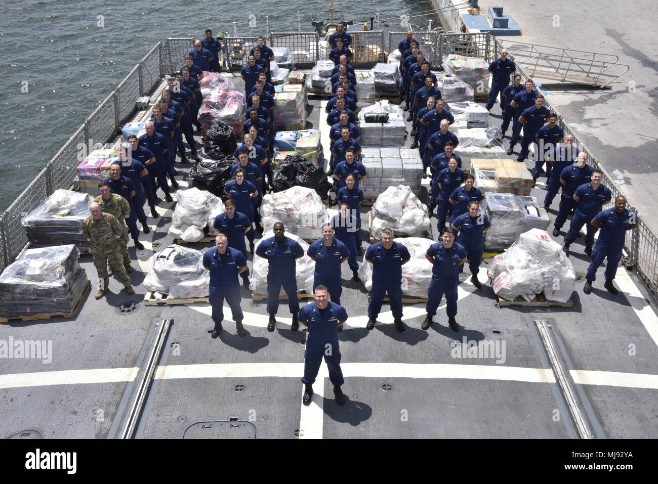 The crew of the Coast Guard Cutter Legare stands on the flight deck of ...