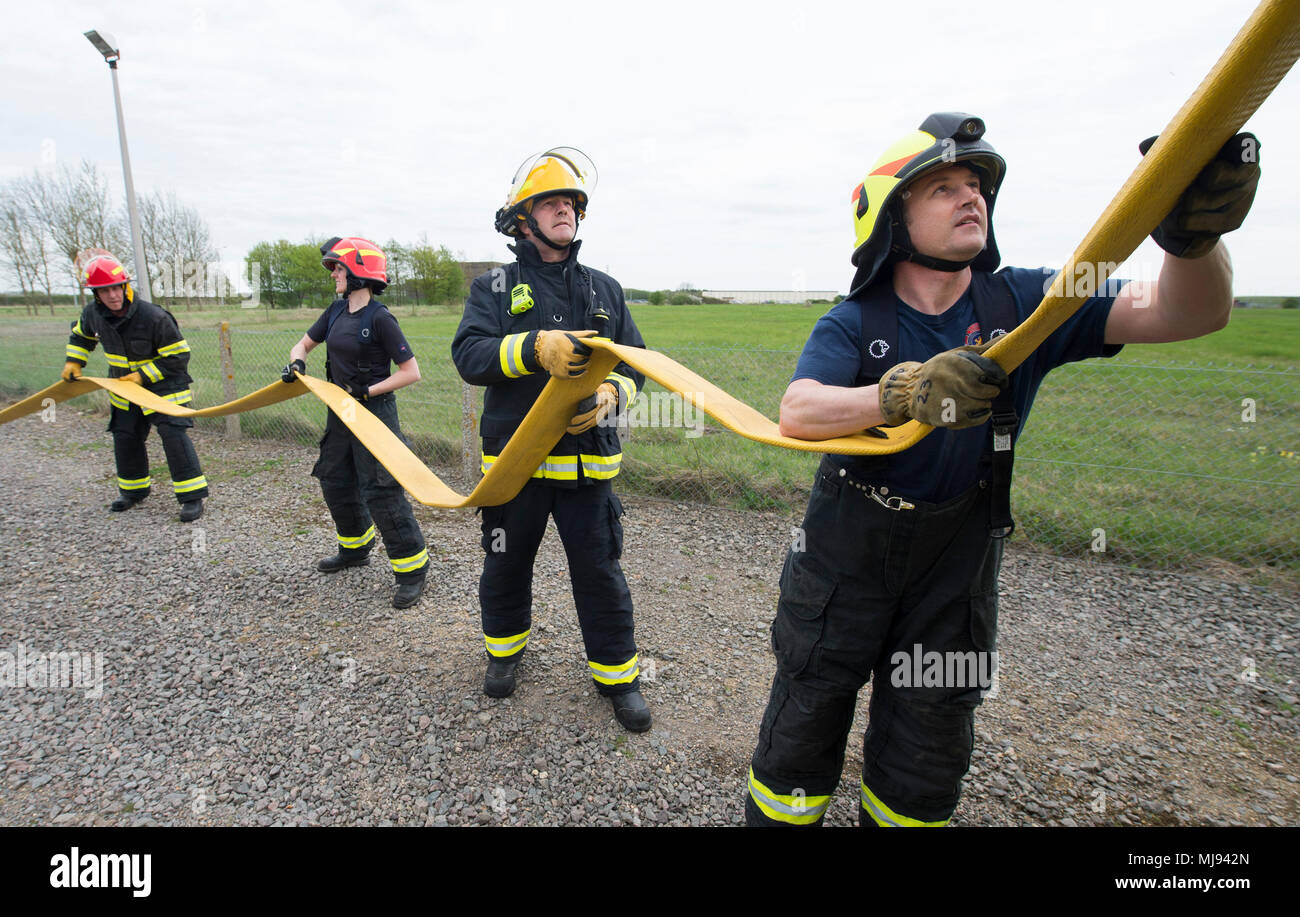 Firefighters with the 423rd Civil Engineering Squadron load a fire hose ...