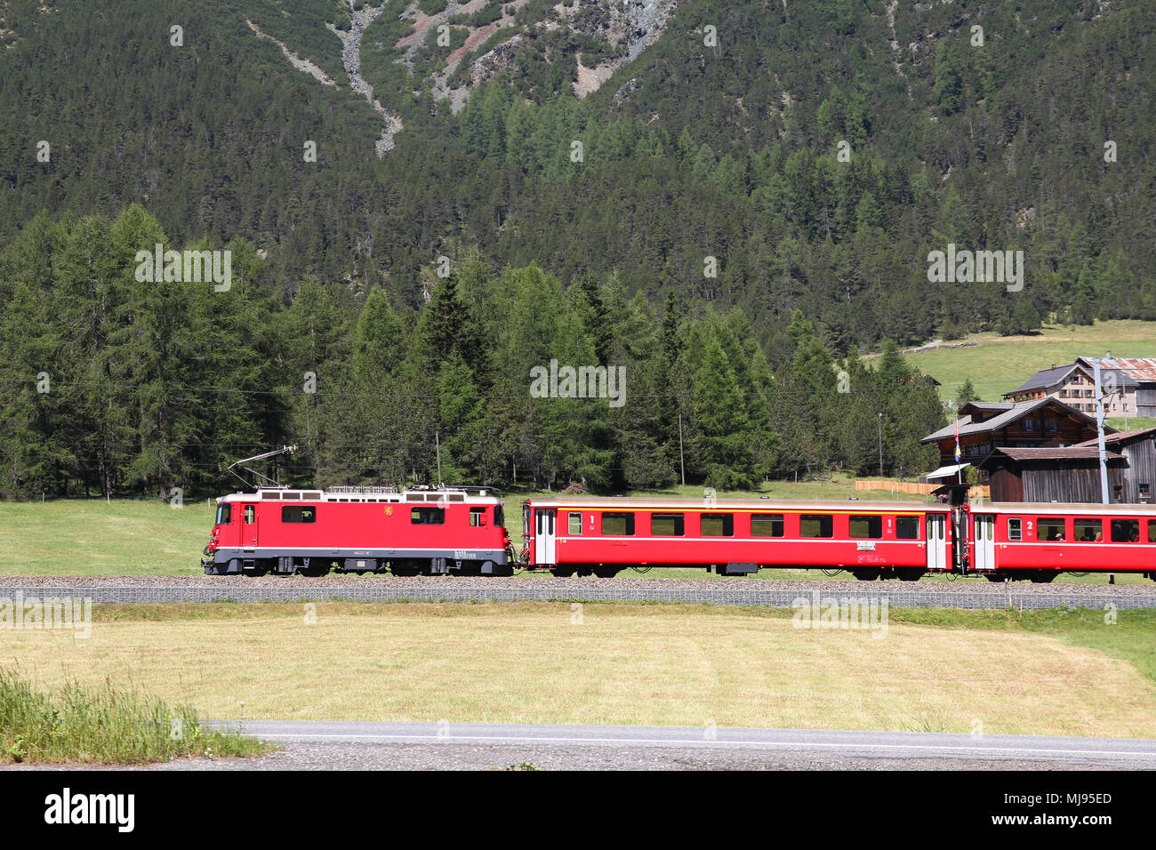 Red train on a scenic route in Grisons (Graubunden) Canton of ...