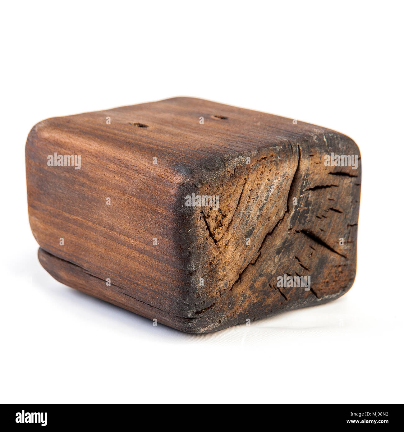 Big old dark cube is cut out from a solid trunk of an old wood ...