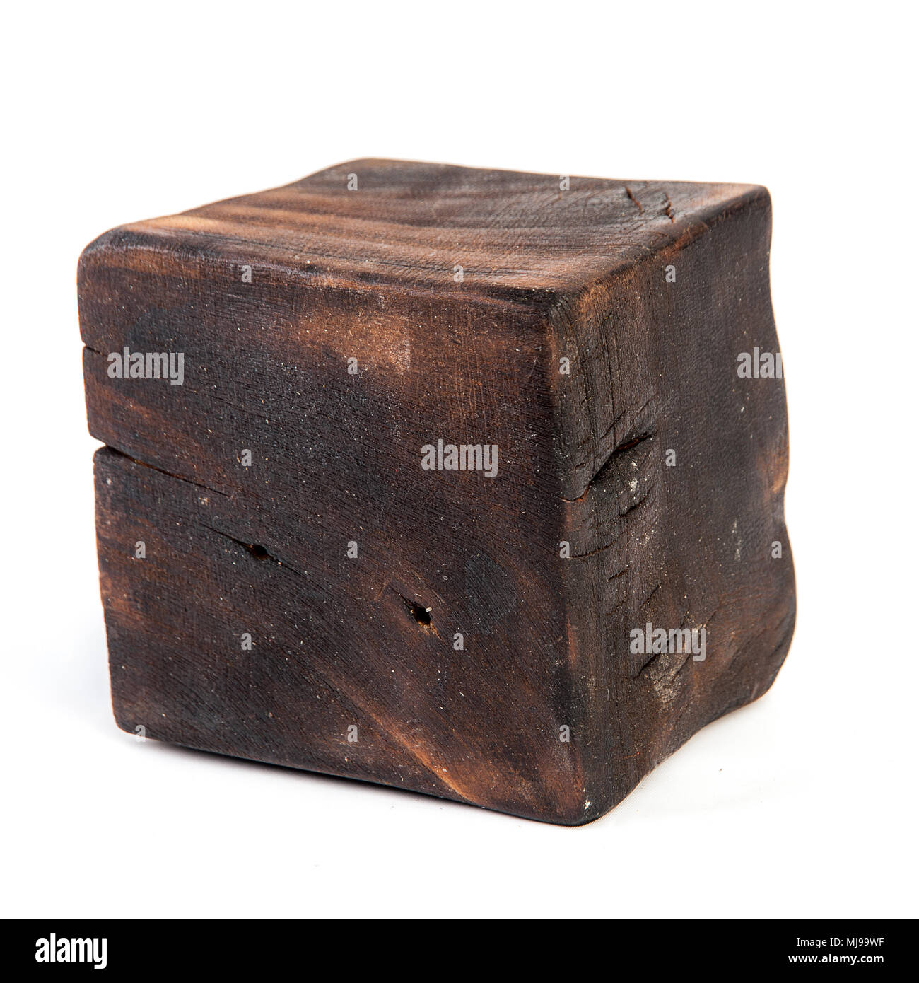 Big old dark cube is cut out from a solid trunk of an old wood ...