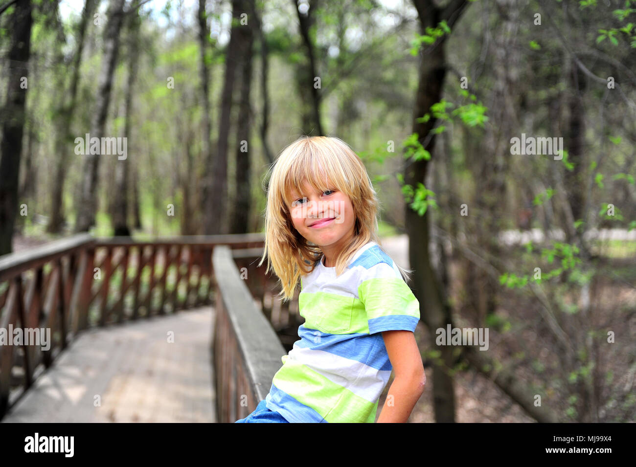 Boy sitting on wooden fence hi-res stock photography and images - Alamy