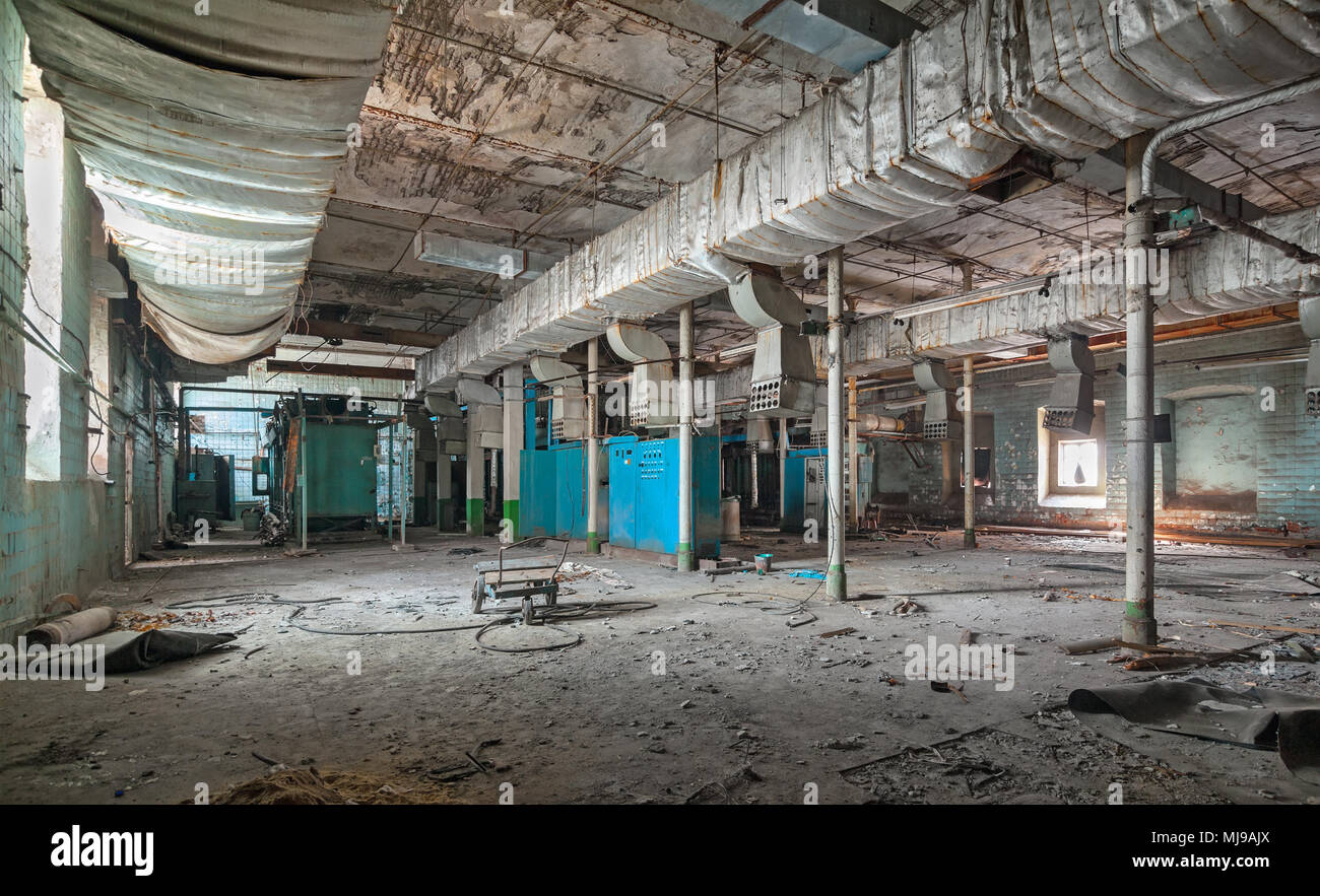 Destroyed production room of an old abandoned textile factory with ...
